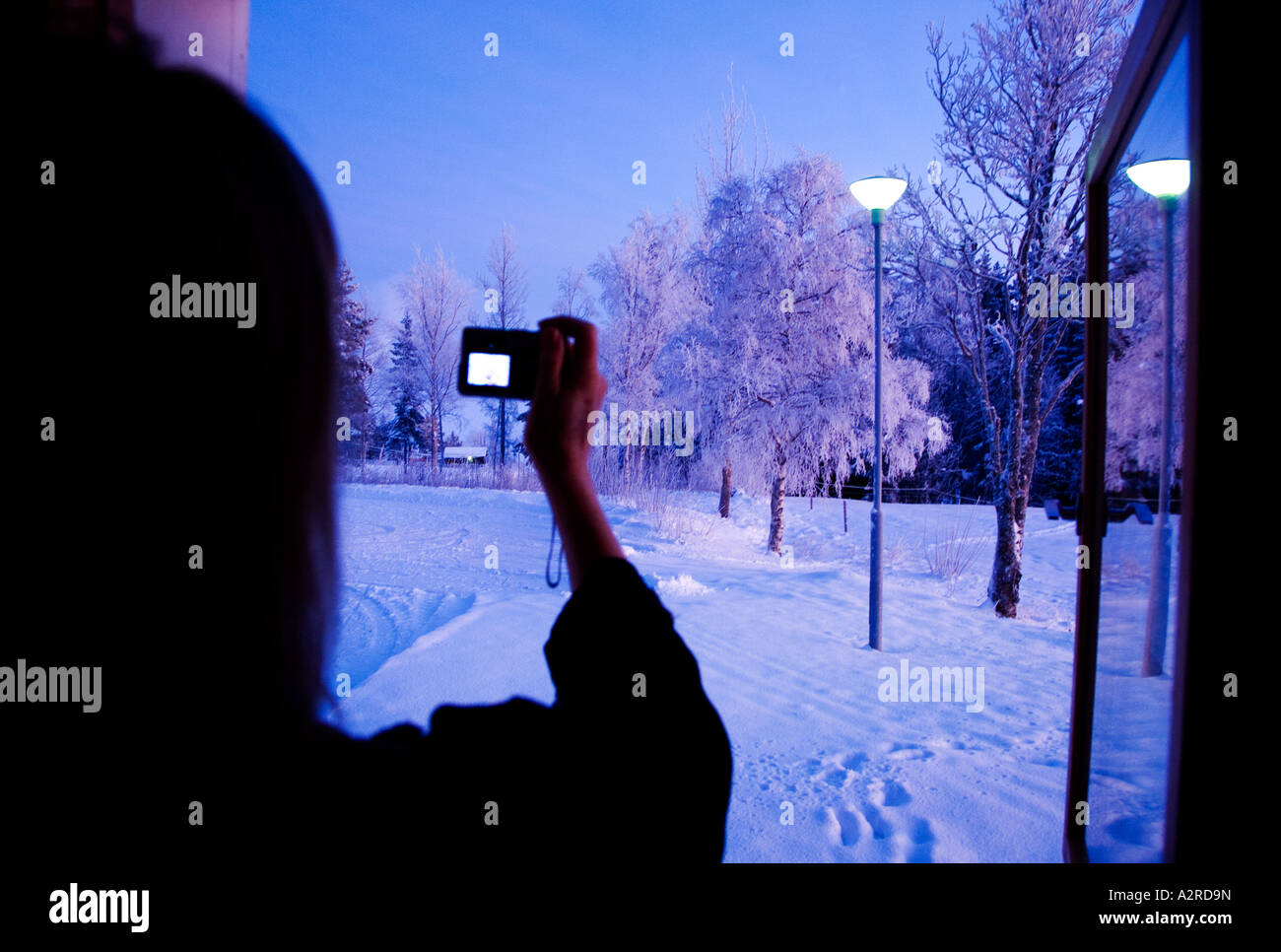 woman taking a picture through a window with a camera on a cellphone ...