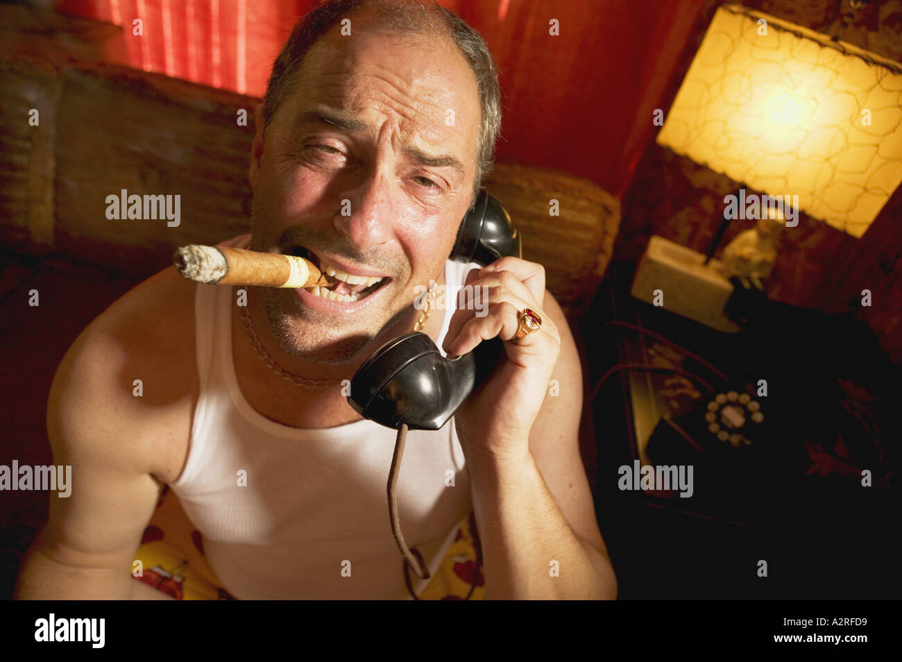 Man on the phone smoking a cigar Stock Photo - Alamy