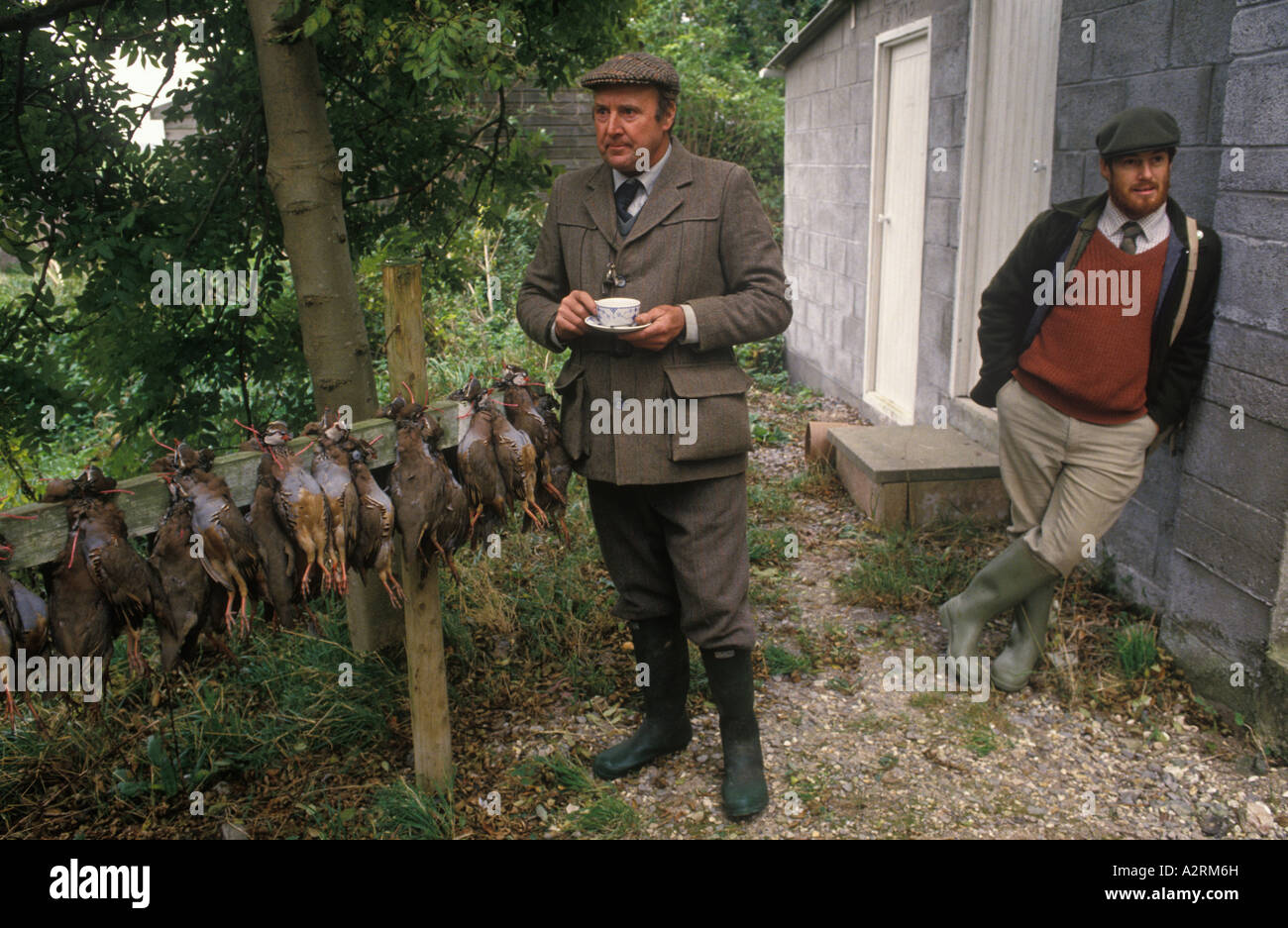 Game Keepers outside hunting lodge Guns, estate guests inside eating a ...