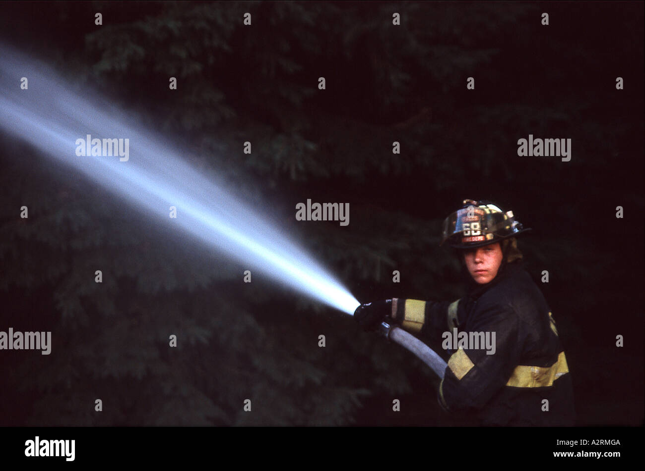 A fire fighter spraying with a fire hose Stock Photo - Alamy