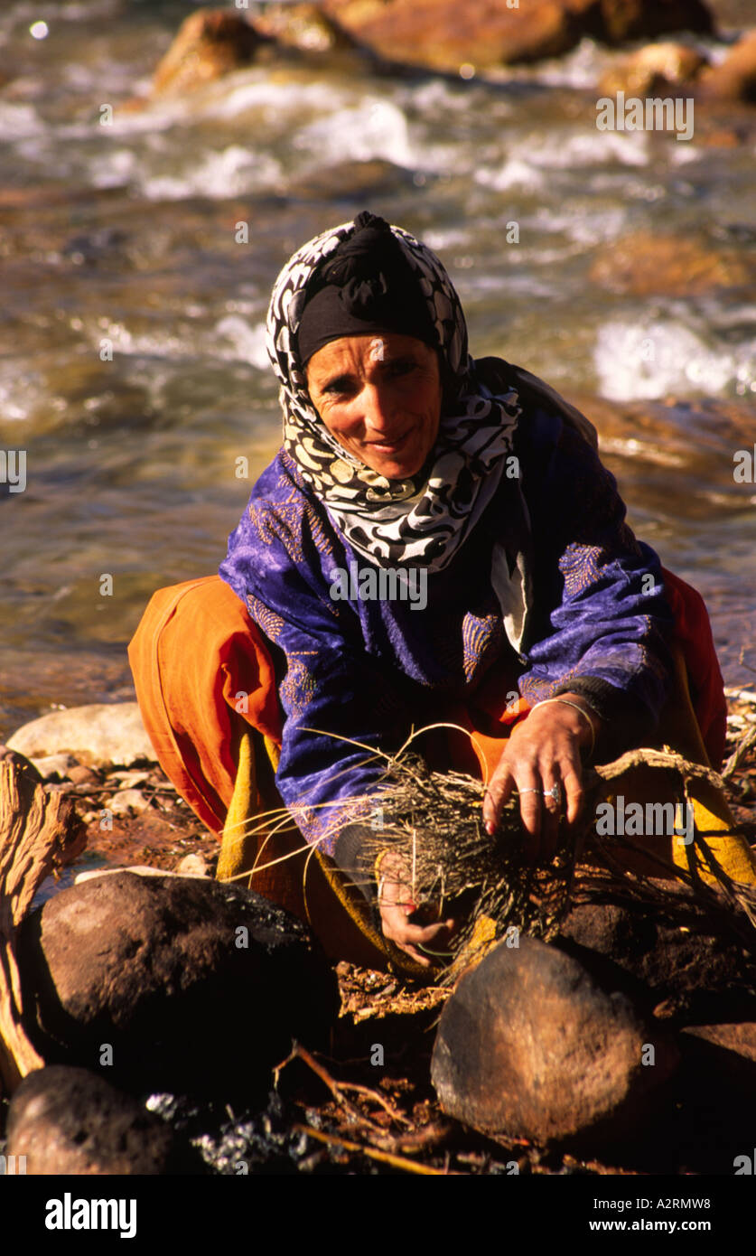 Woman lighting fire to boil water collected from the river to wash her ...