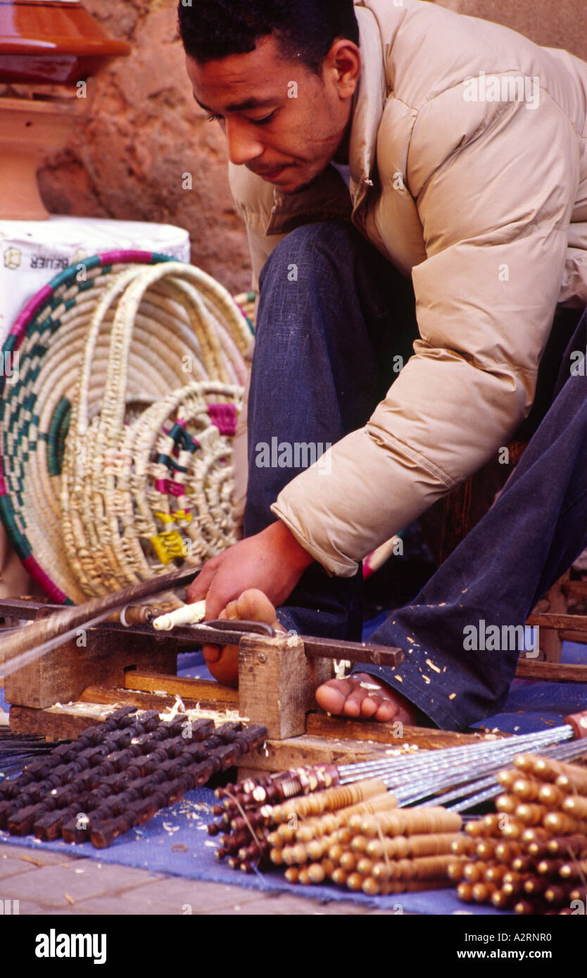 Moroccan man carves kebab skewers from cedar wood using his feet ...