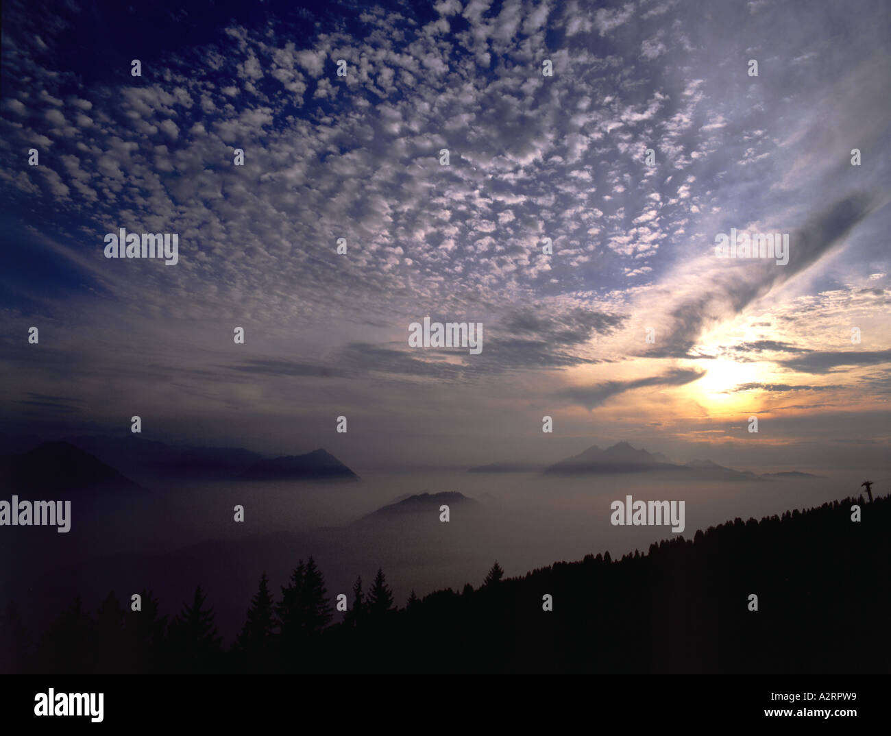 Sun breaking through the clouds and mist over the swiss mountains Stock ...