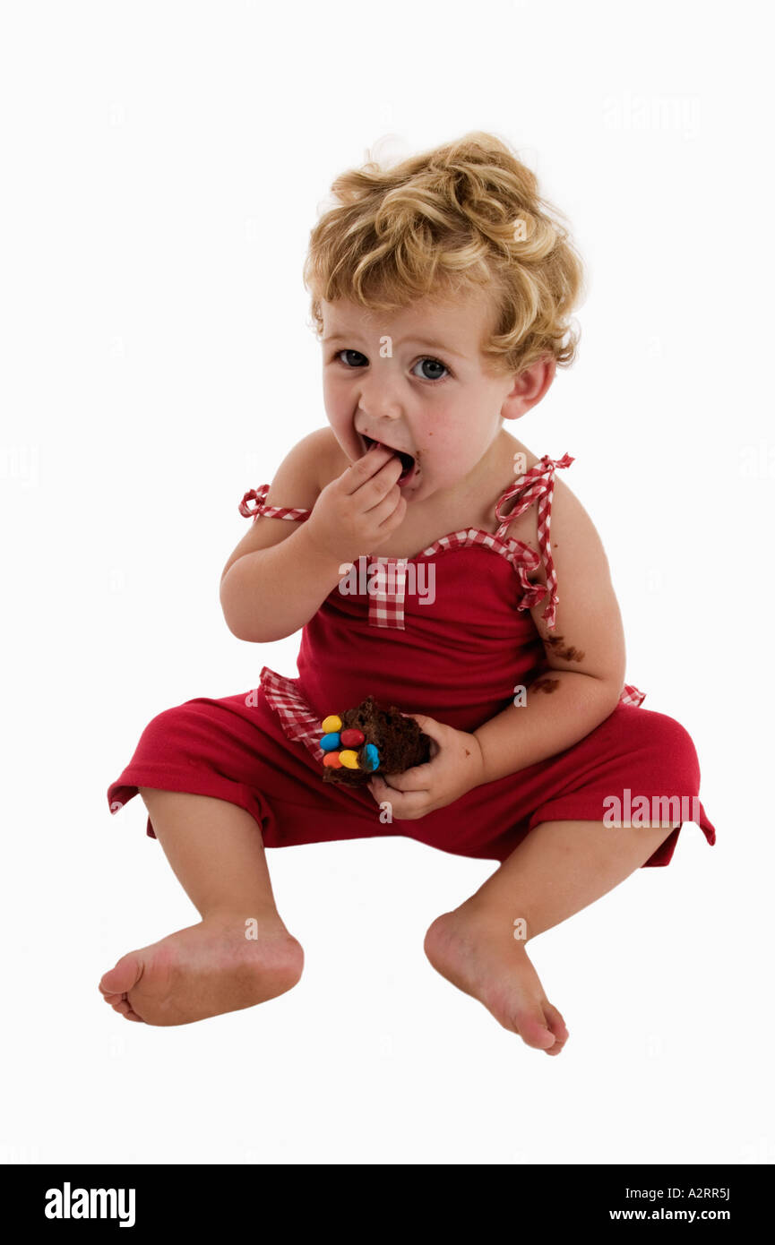 Child 18 months eating chocolate cake Model released Studio shot Stock ...