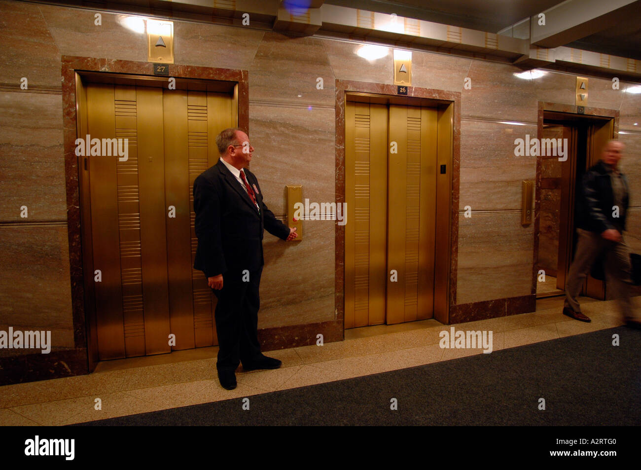 Elevator starter at bank of elevators in an office building Stock Photo ...