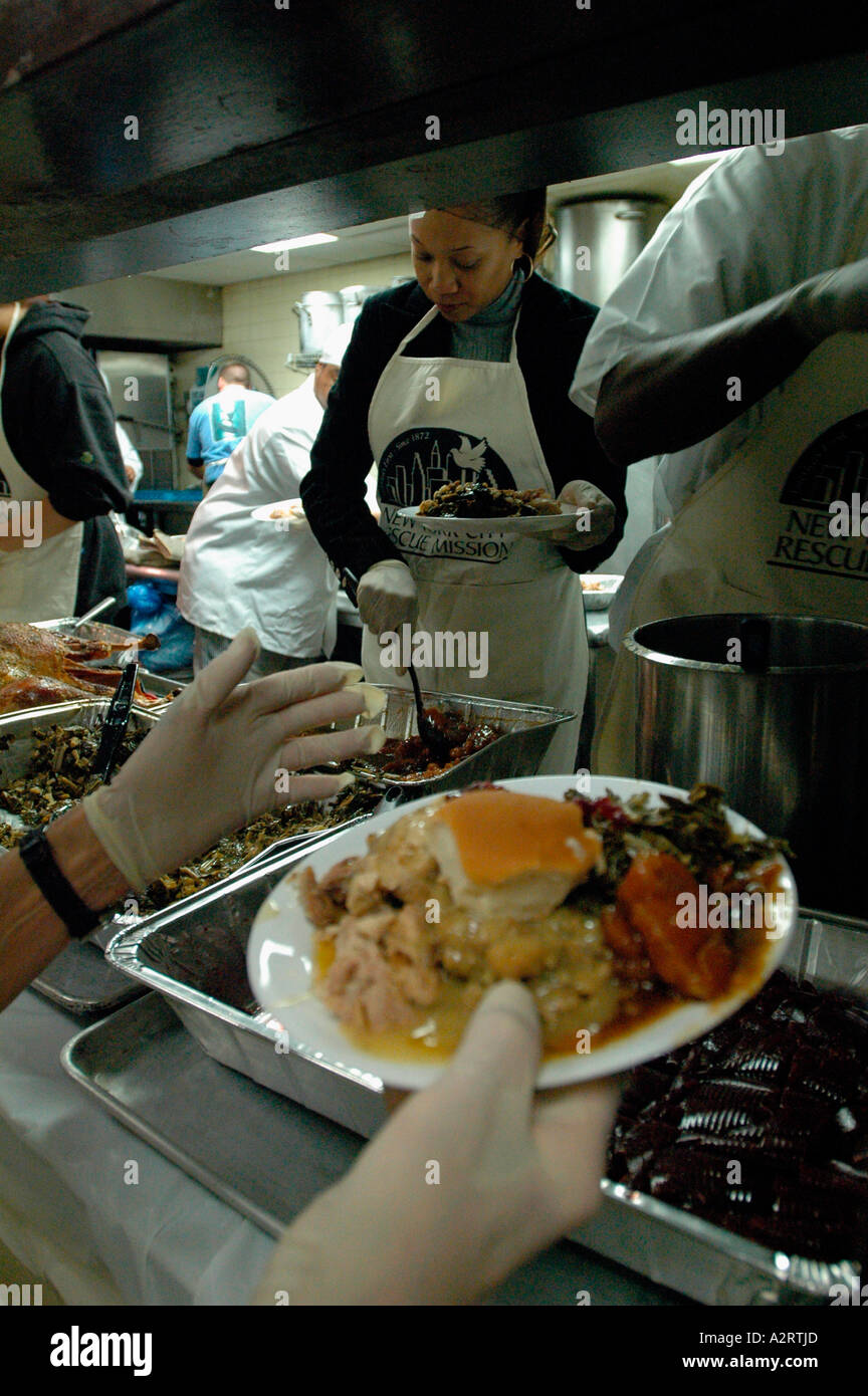 Volunteers prepare and serve Thanksgiving dinner to the homeless and ...