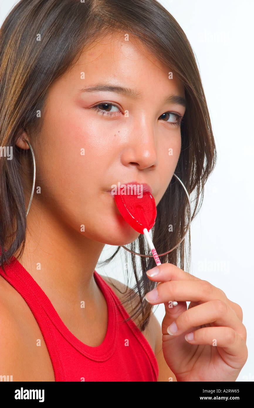 Youg asian woman eating a heart-shaped lollipop Stock Photo - Alamy