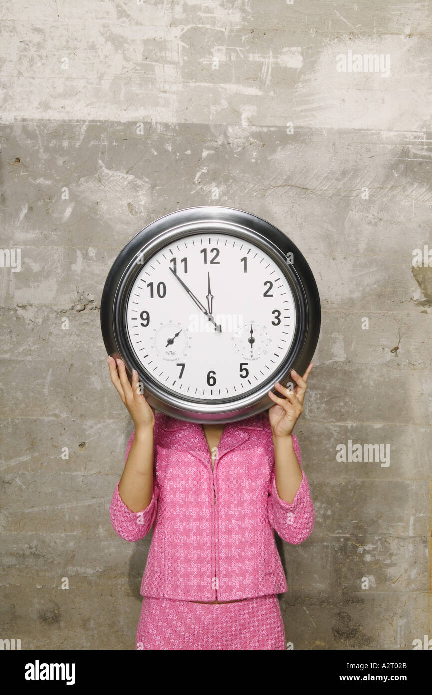 Woman holding a clock in front of her face Stock Photo - Alamy