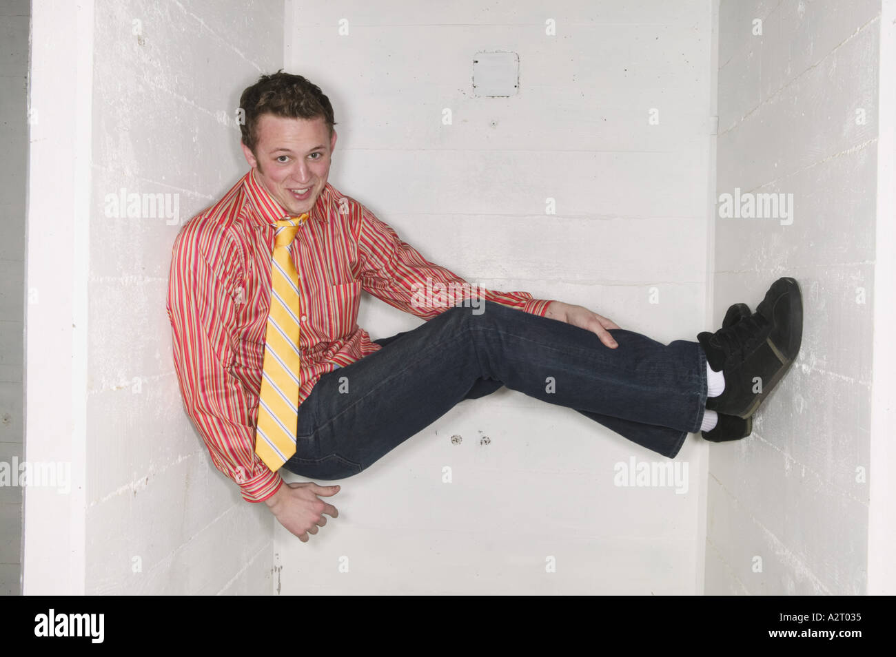 A young man caught between two walls Stock Photo - Alamy