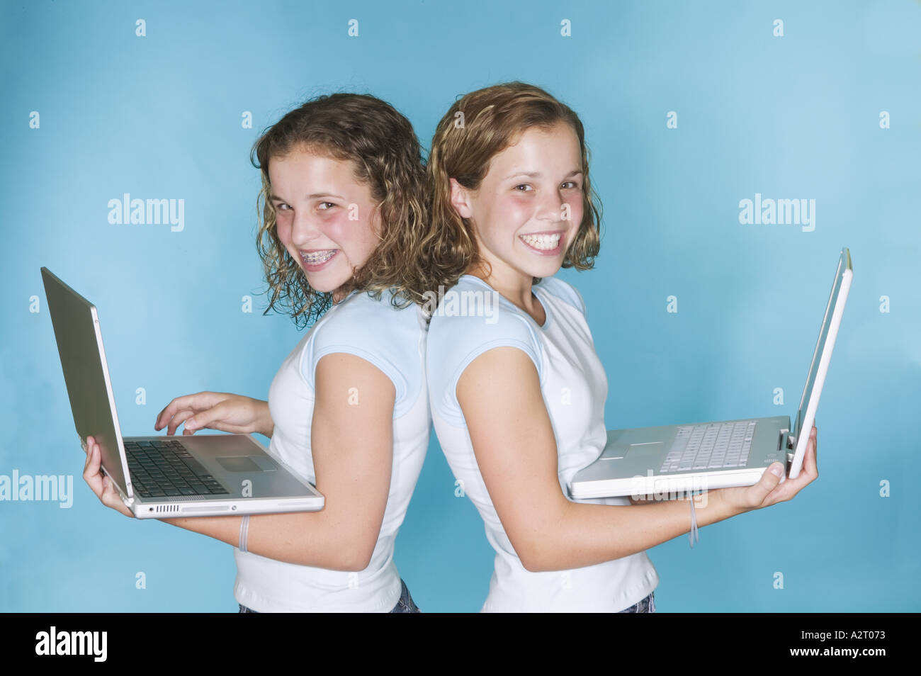 Teen twin girls using laptop computers Stock Photo - Alamy