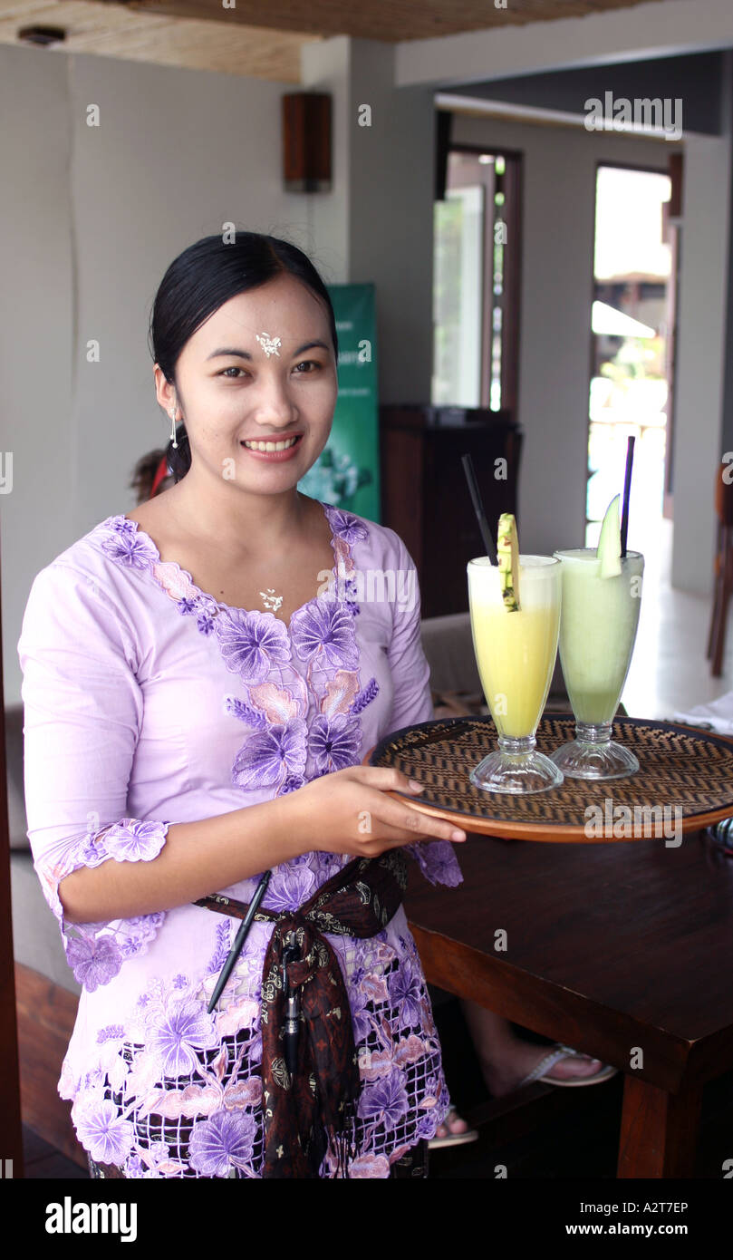 smiling Balinese waitress with glasses on a salver Stock Photo - Alamy