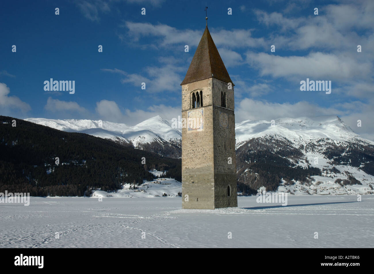 Tower of drowned church of Graun in frozen hydroelectric damed lake ...