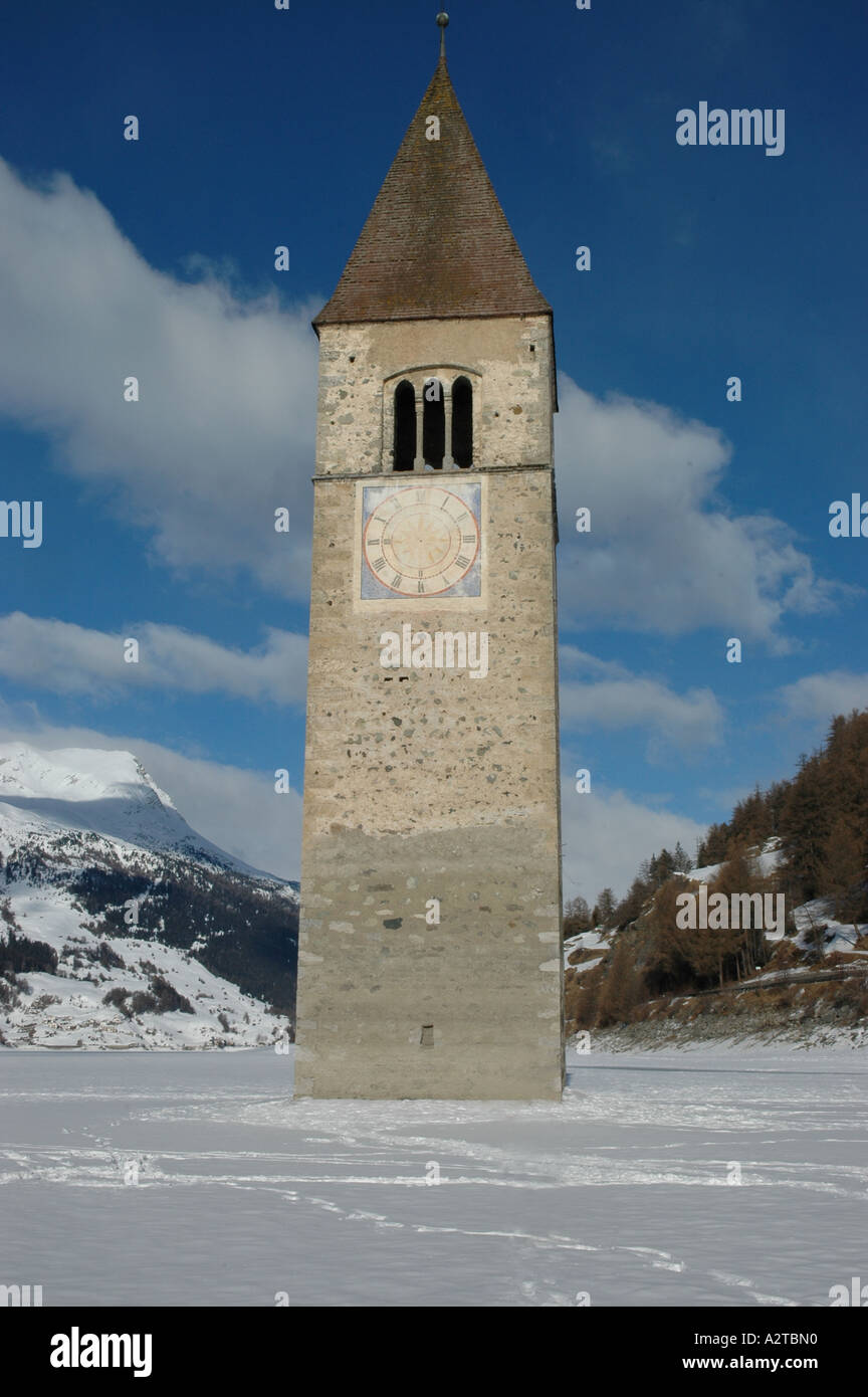 Tower of drowned church of Graun in frozen hydroelectric damed lake ...