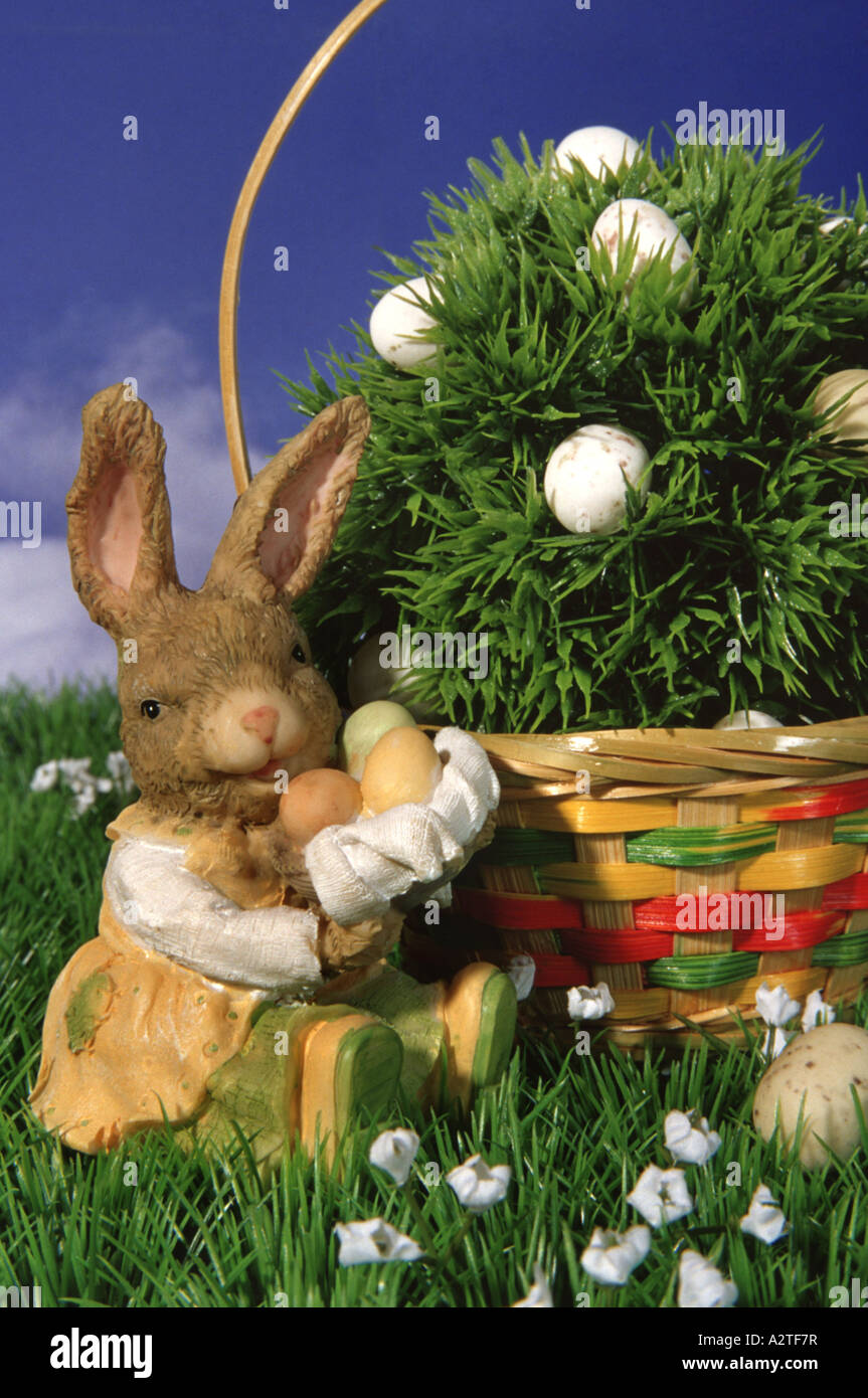 easter bunny sitting in front of a shrub with easter eggs Stock Photo ...