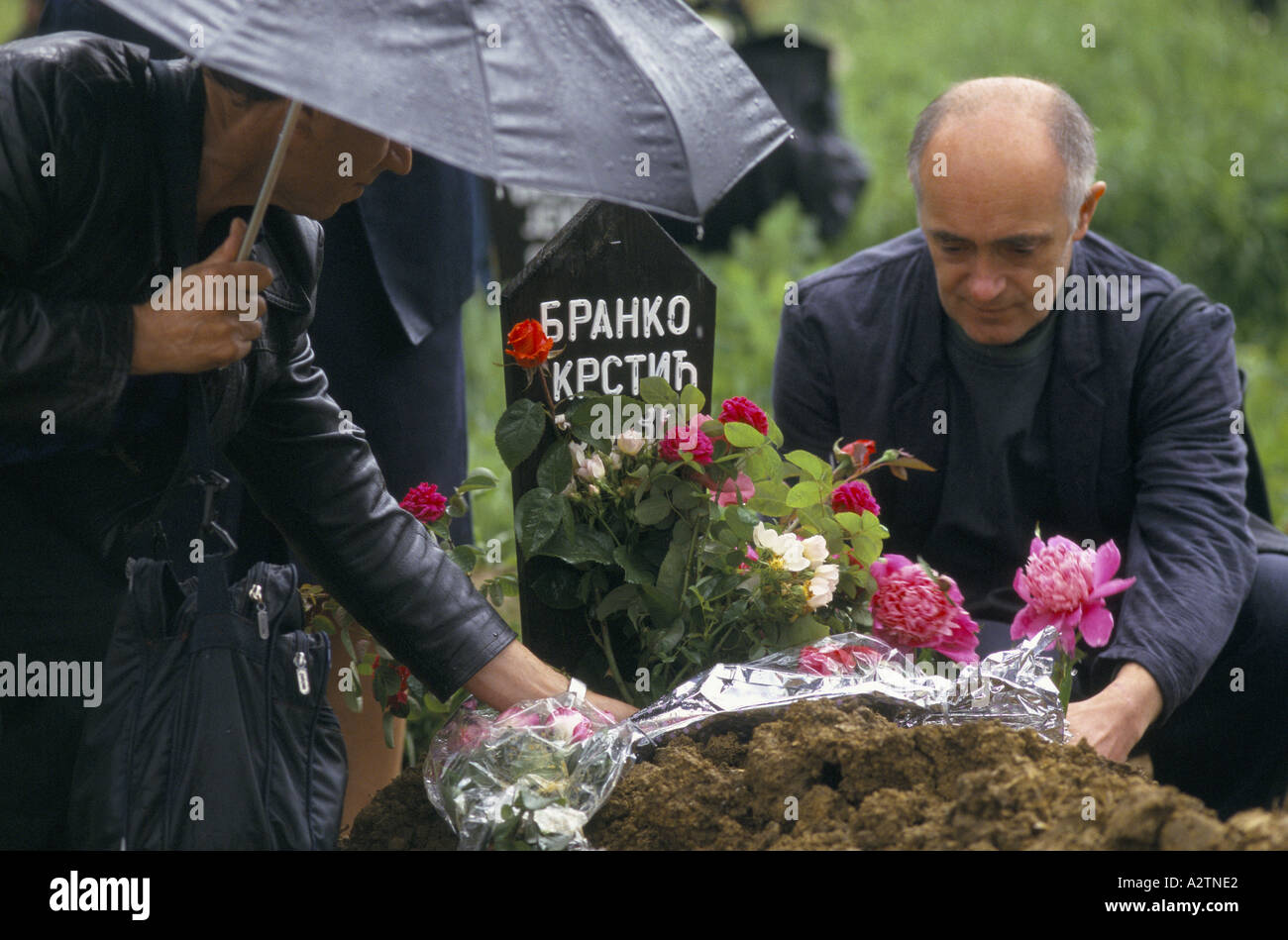 sarajevo june 1995 mourners in black laying flowers on the grave at a ... sarajevo june 1995 mourners in black laying flowers on the grave at a ...