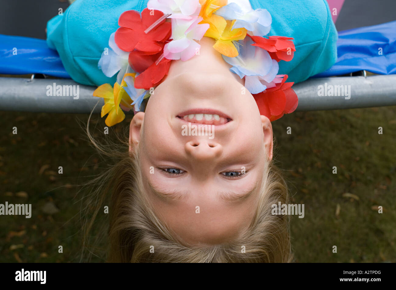 Girl on edge of trampoline Stock Photo - Alamy