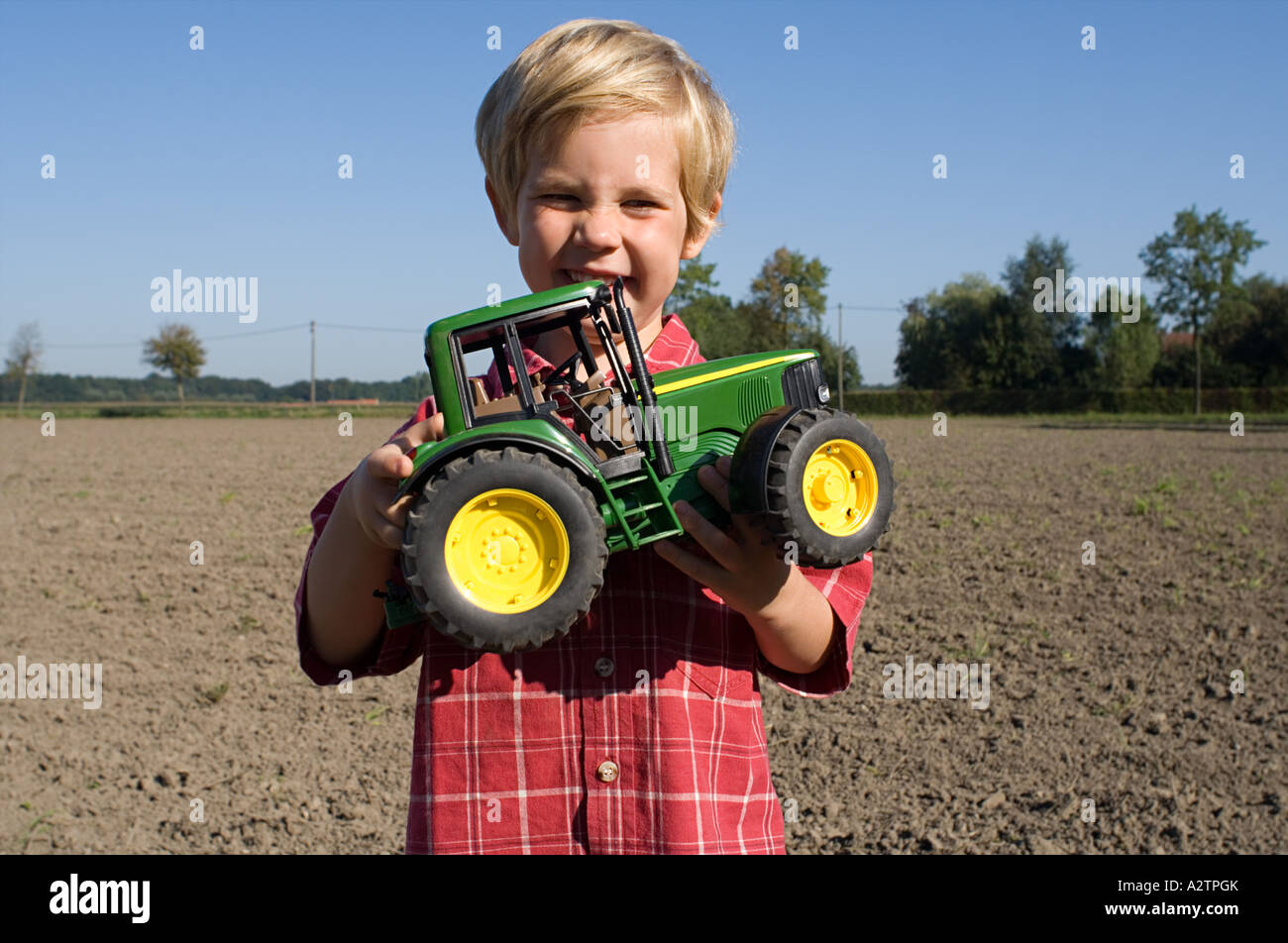 Boy with a toy tractor Stock Photo - Alamy