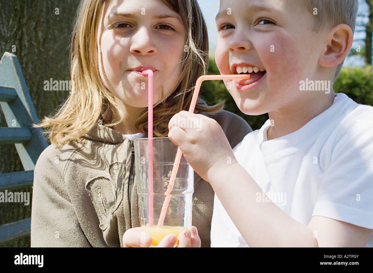Boy and girl sharing drink Stock Photo - Alamy