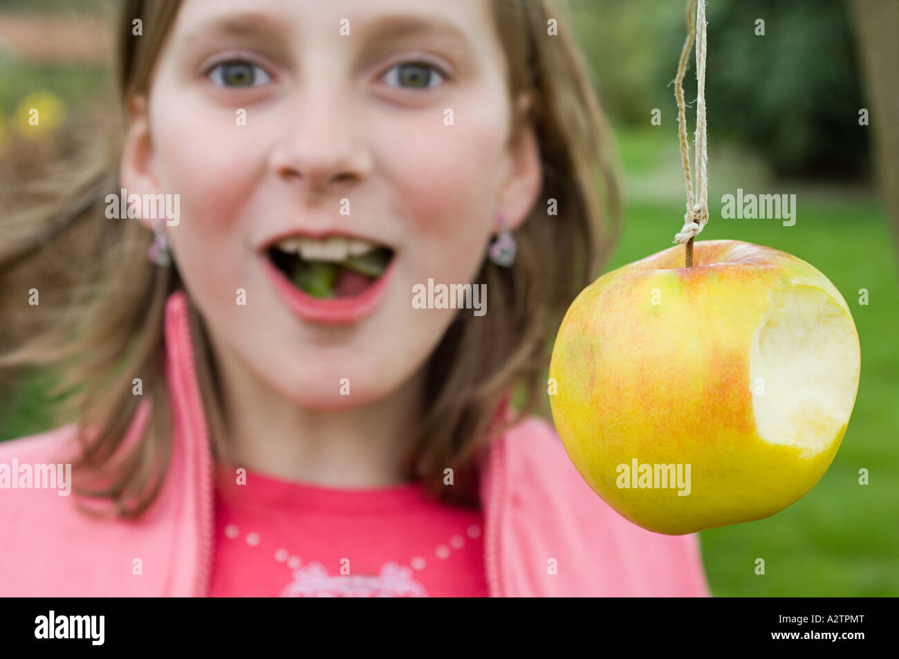 Girl and apple on a string Stock Photo - Alamy