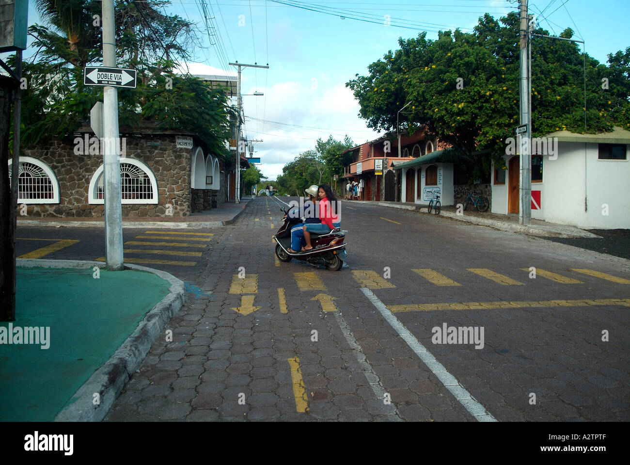 Couple riding a scooter in Santa Cruz, Ecuador Stock Photo - Alamy