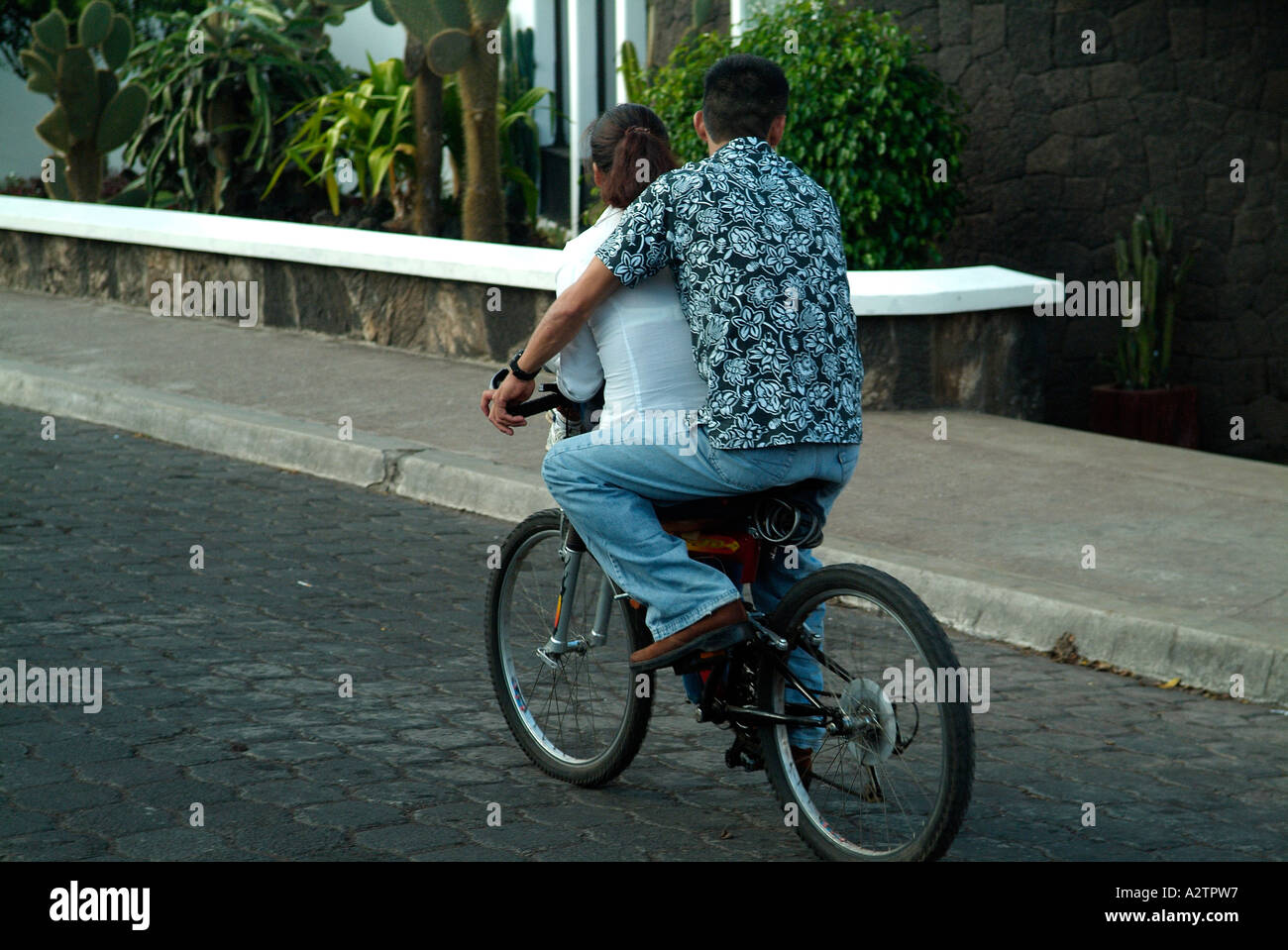 People riding a cycle in Santa Cruz, Ecuador Stock Photo - Alamy
