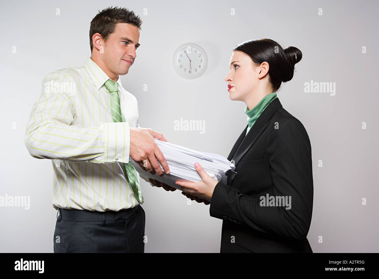 Businessman handing colleague paperwork Stock Photo - Alamy