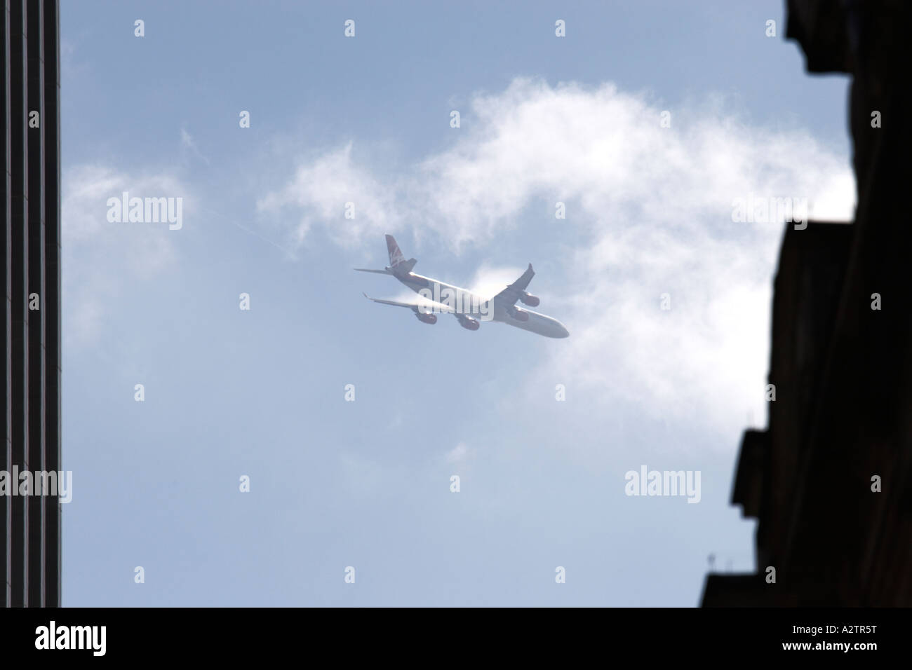 Aircraft flying through cloud between office buildings in City of ...