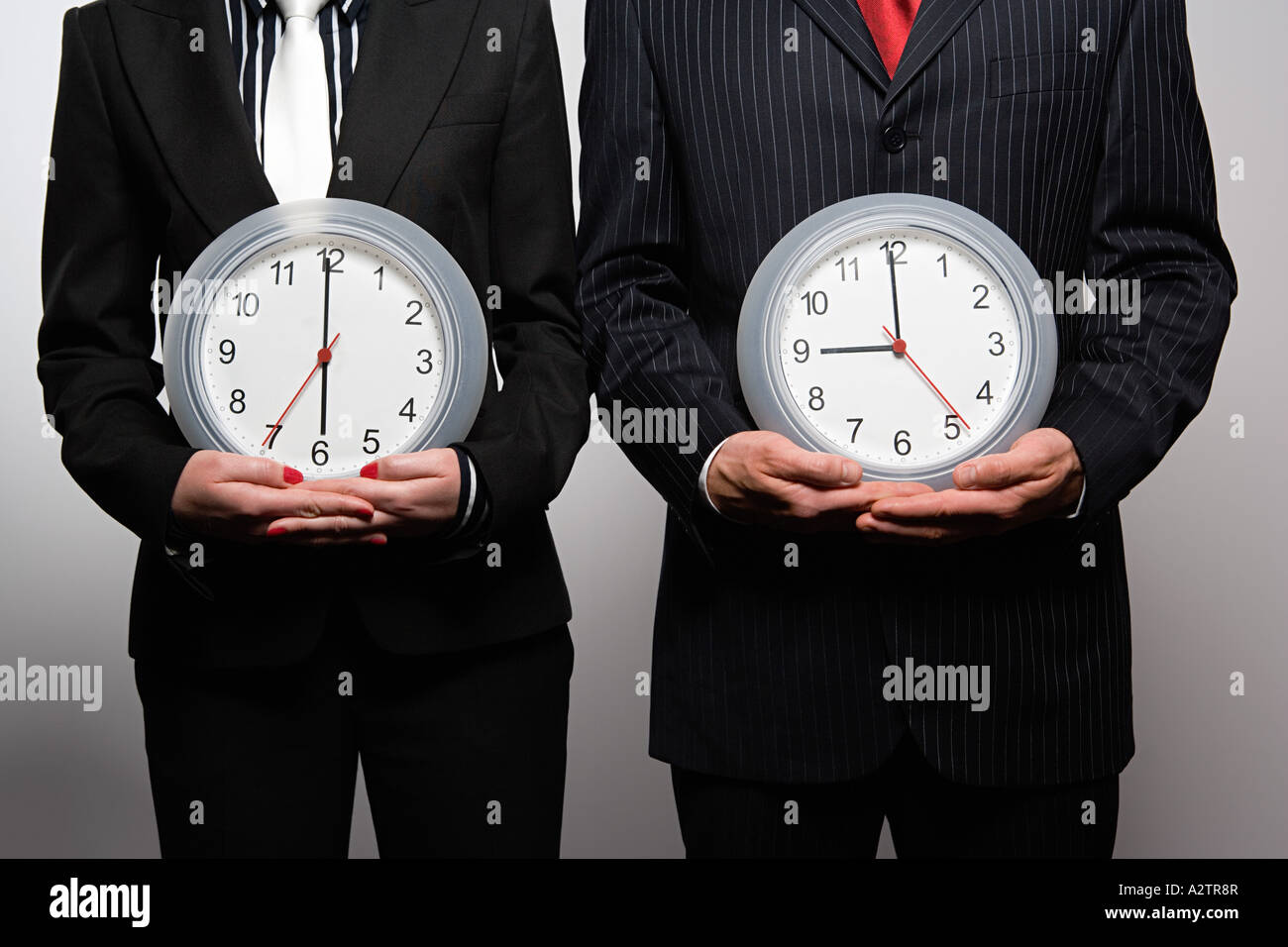 Businesspeople holding clocks Stock Photo - Alamy