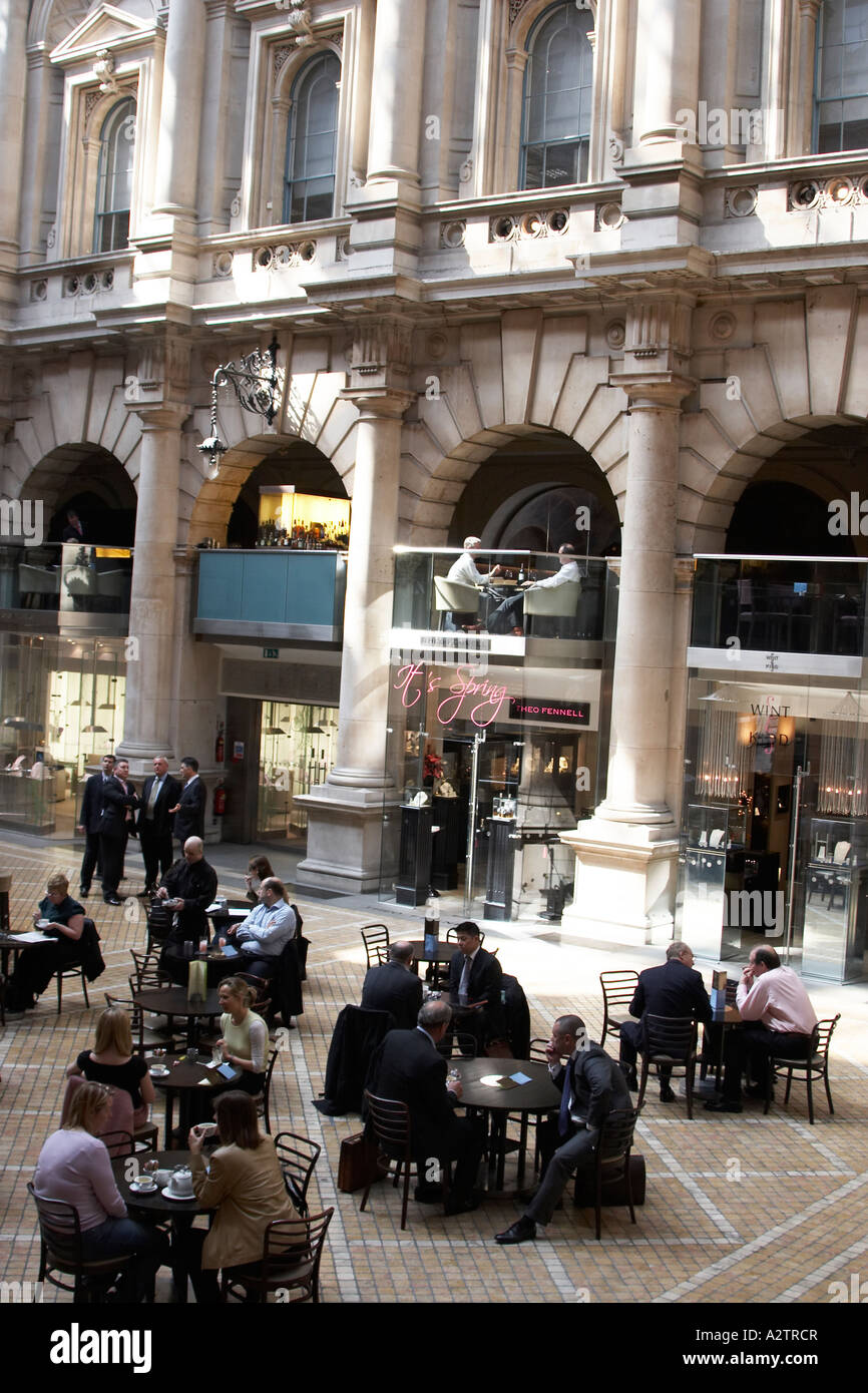 People relaxing eating drinking and talking in atrium courtyard ...