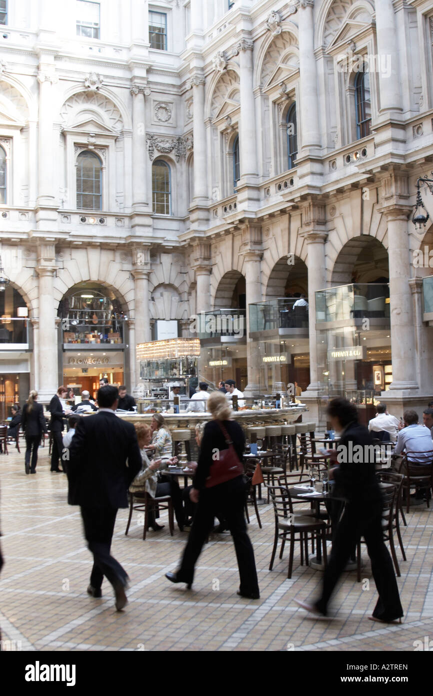 People relaxing eating drinking and talking in atrium courtyard ...