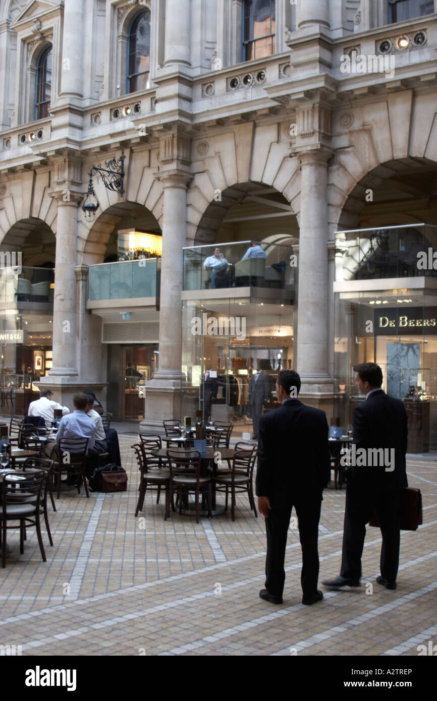 People relaxing eating drinking and talking in atrium courtyard ...