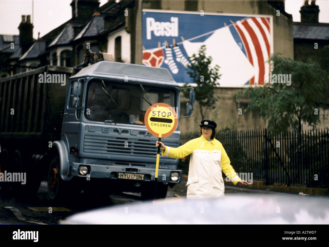 lollipop lady stopping traffic with stop children sign standing in road ...