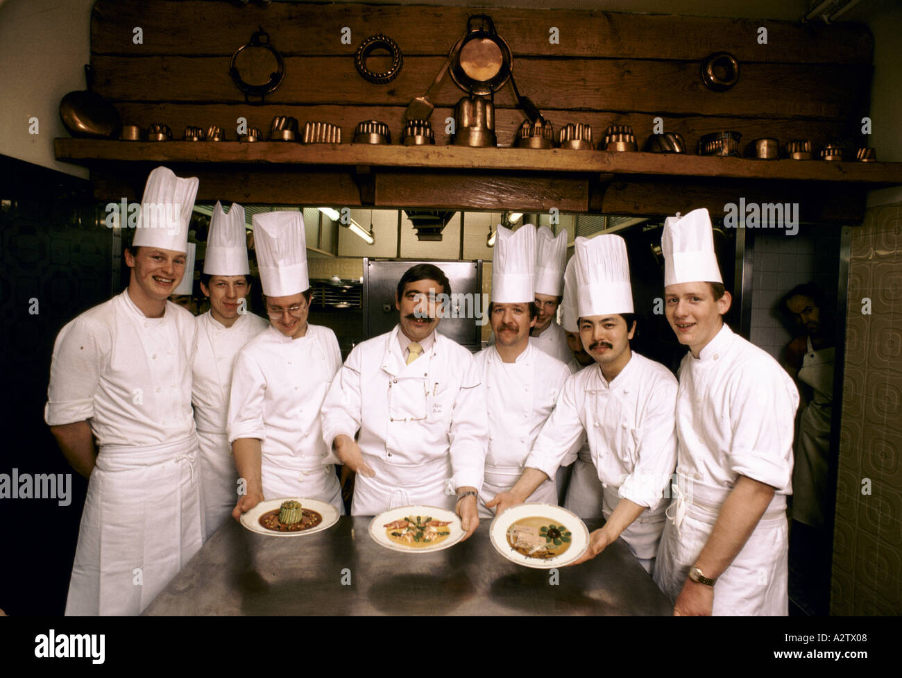 line up of male chefs with plates of food Stock Photo - Alamy