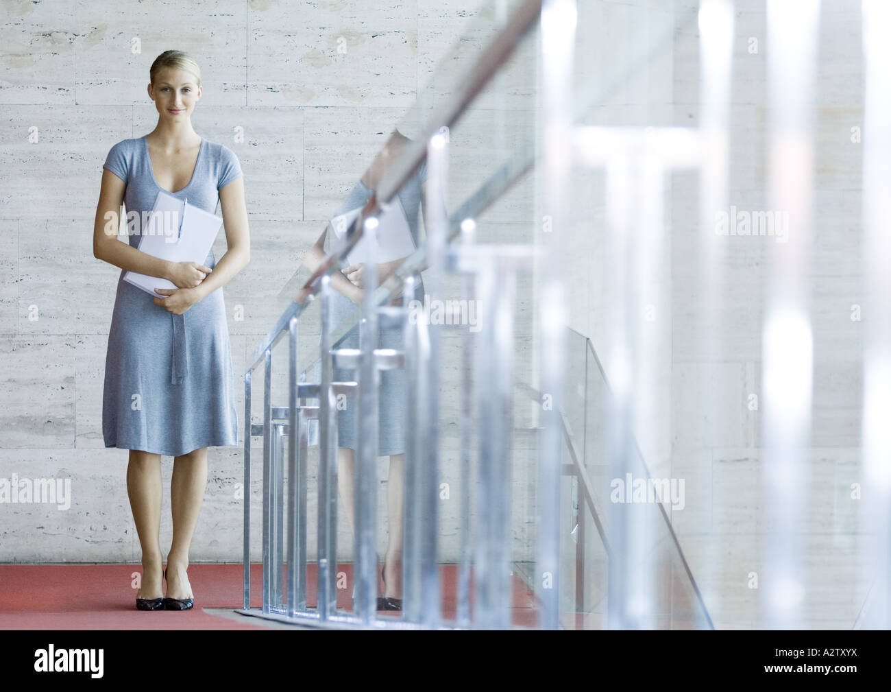 Young woman standing with file folder, full length portrait Stock Photo ...