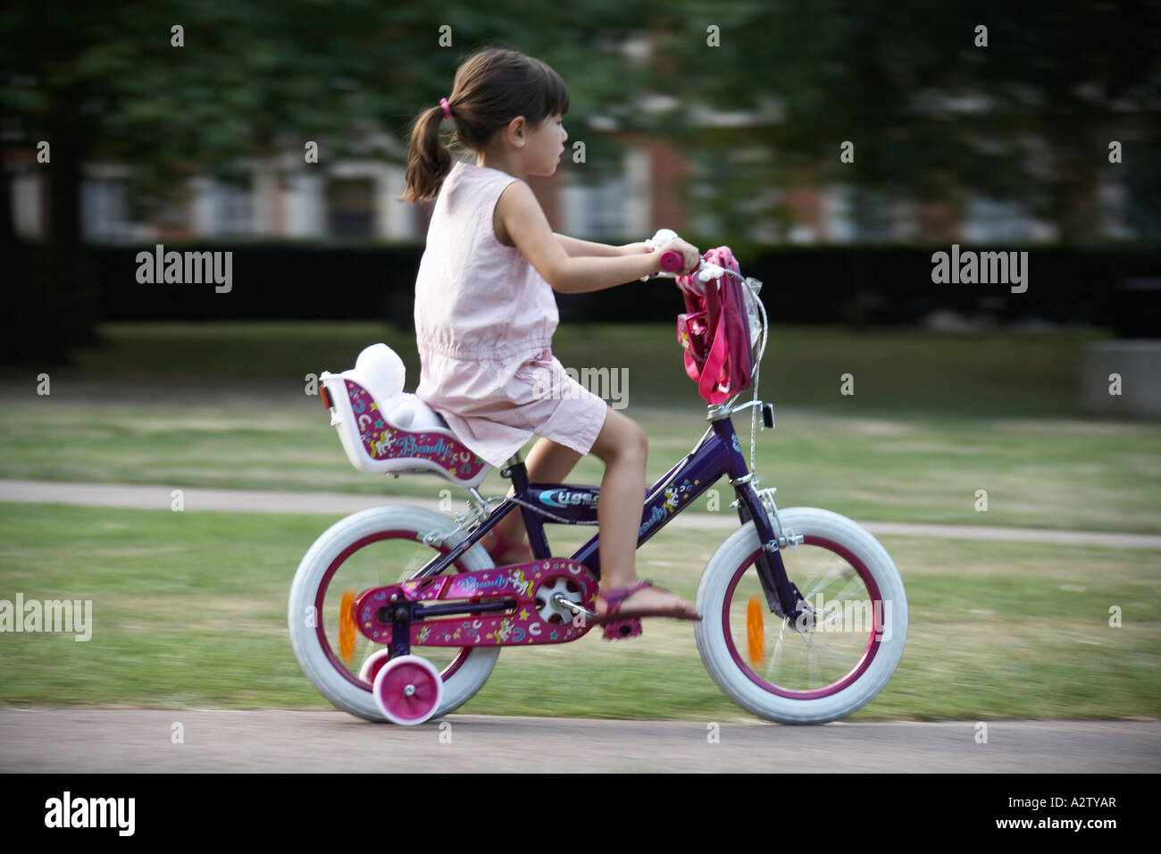 Child riding a bike with stabilisers hi-res stock photography and ...