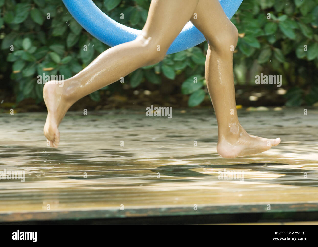 Child running by edge of pool, cropped view of legs Stock Photo - Alamy