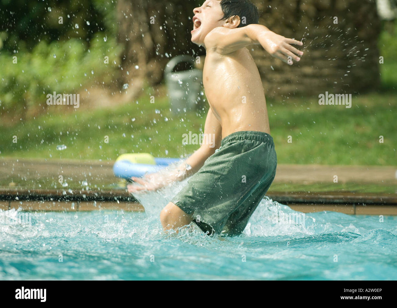 Boy splashing in swimming pool Stock Photo - Alamy
