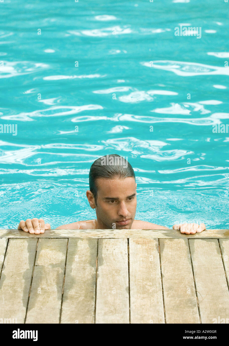Man standing in pool with hands on edge Stock Photo - Alamy
