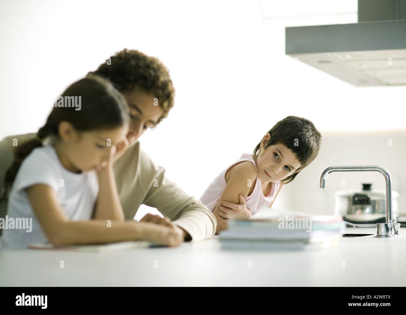 Teenage boy helping younger sister with homework, second sibling ...