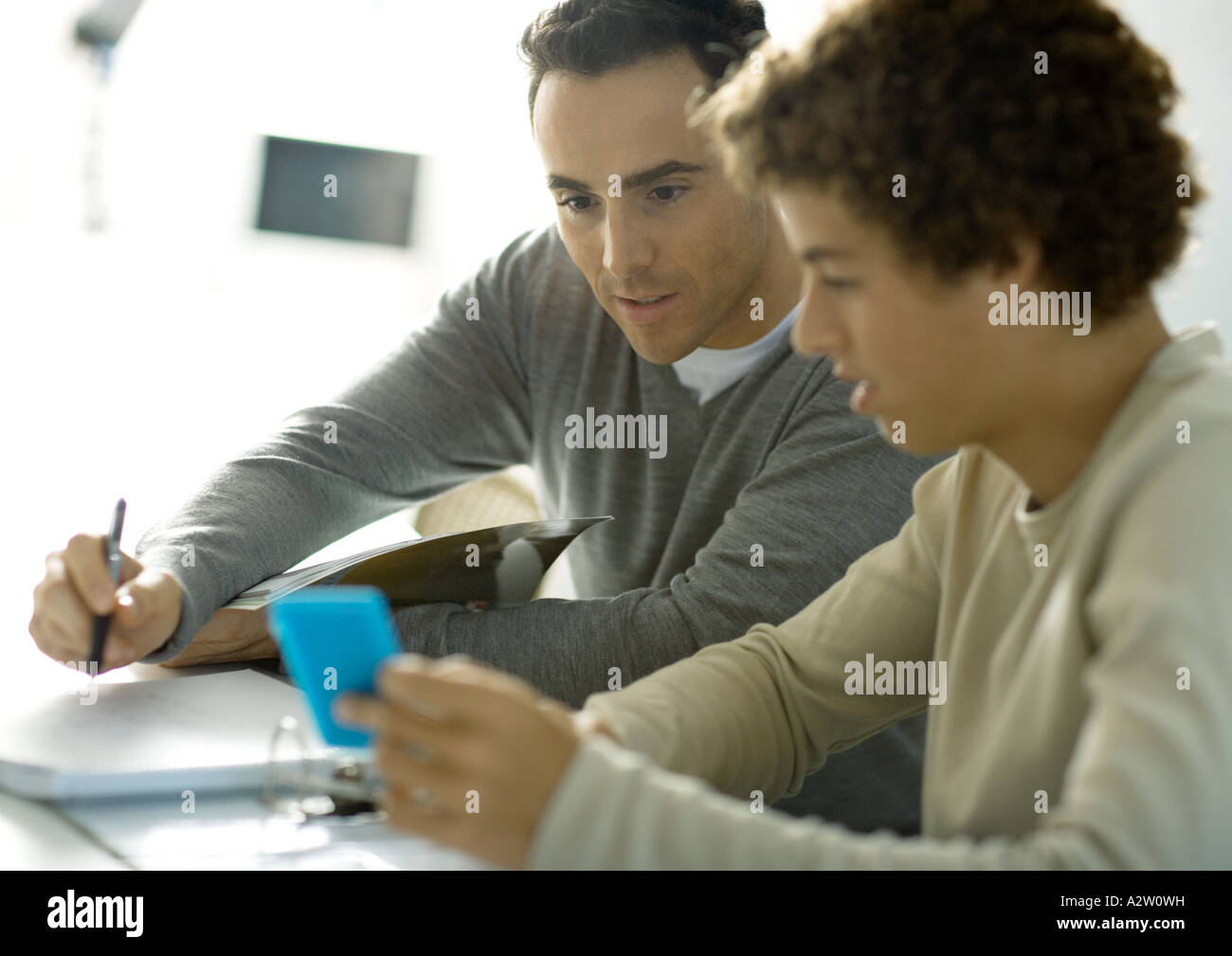 Man helping teenage son with homework Stock Photo - Alamy