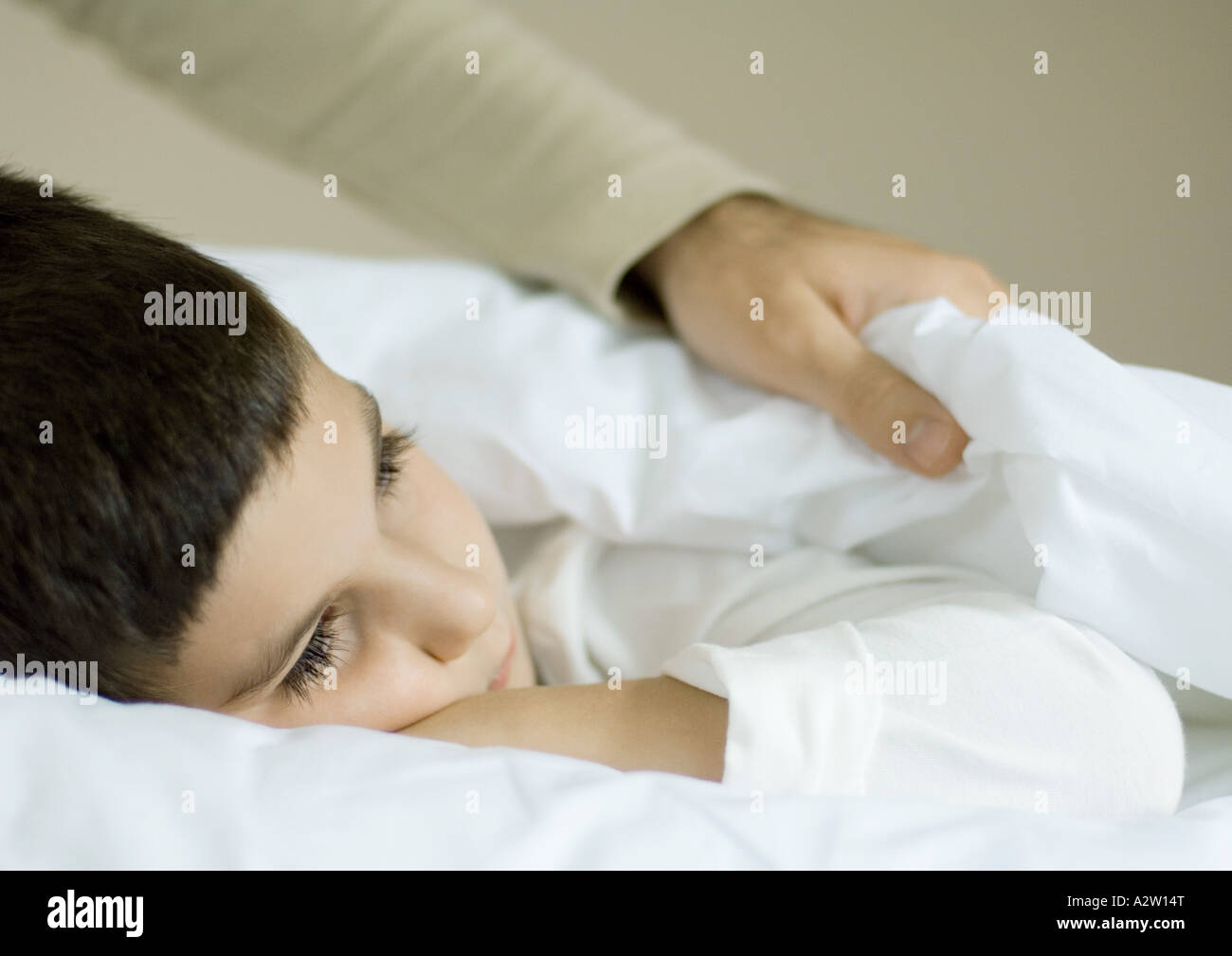 Child lying in bed, father pulling up covers Stock Photo - Alamy