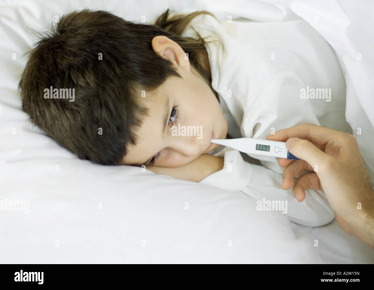 Child lying in bed, having temperature taken Stock Photo - Alamy