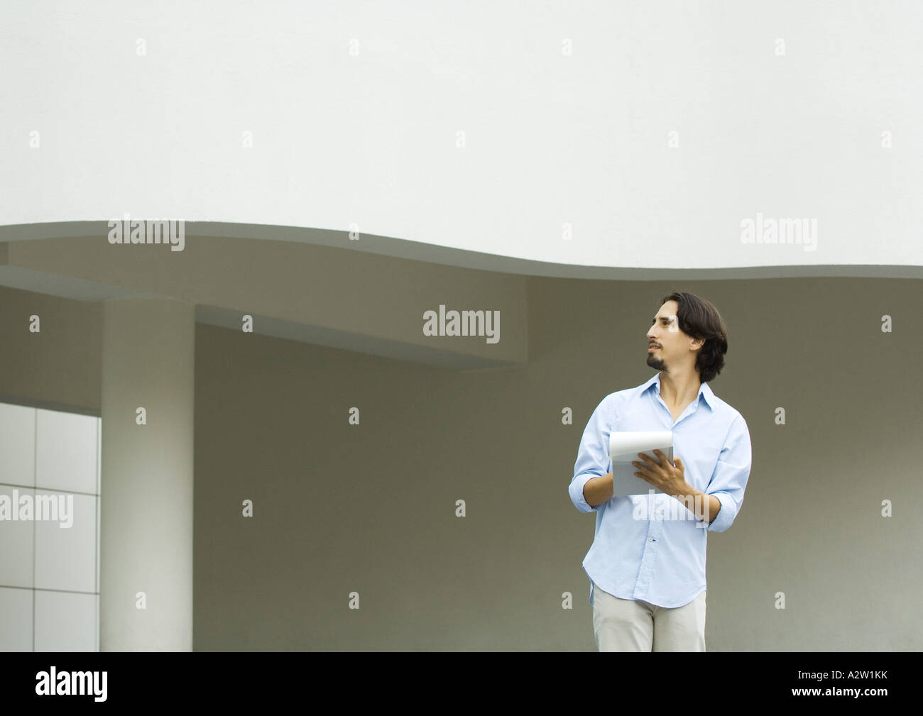 Man standing taking notes on pad of paper Stock Photo - Alamy