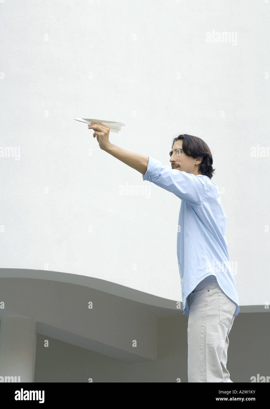 Man standing, aiming paper airplane Stock Photo - Alamy