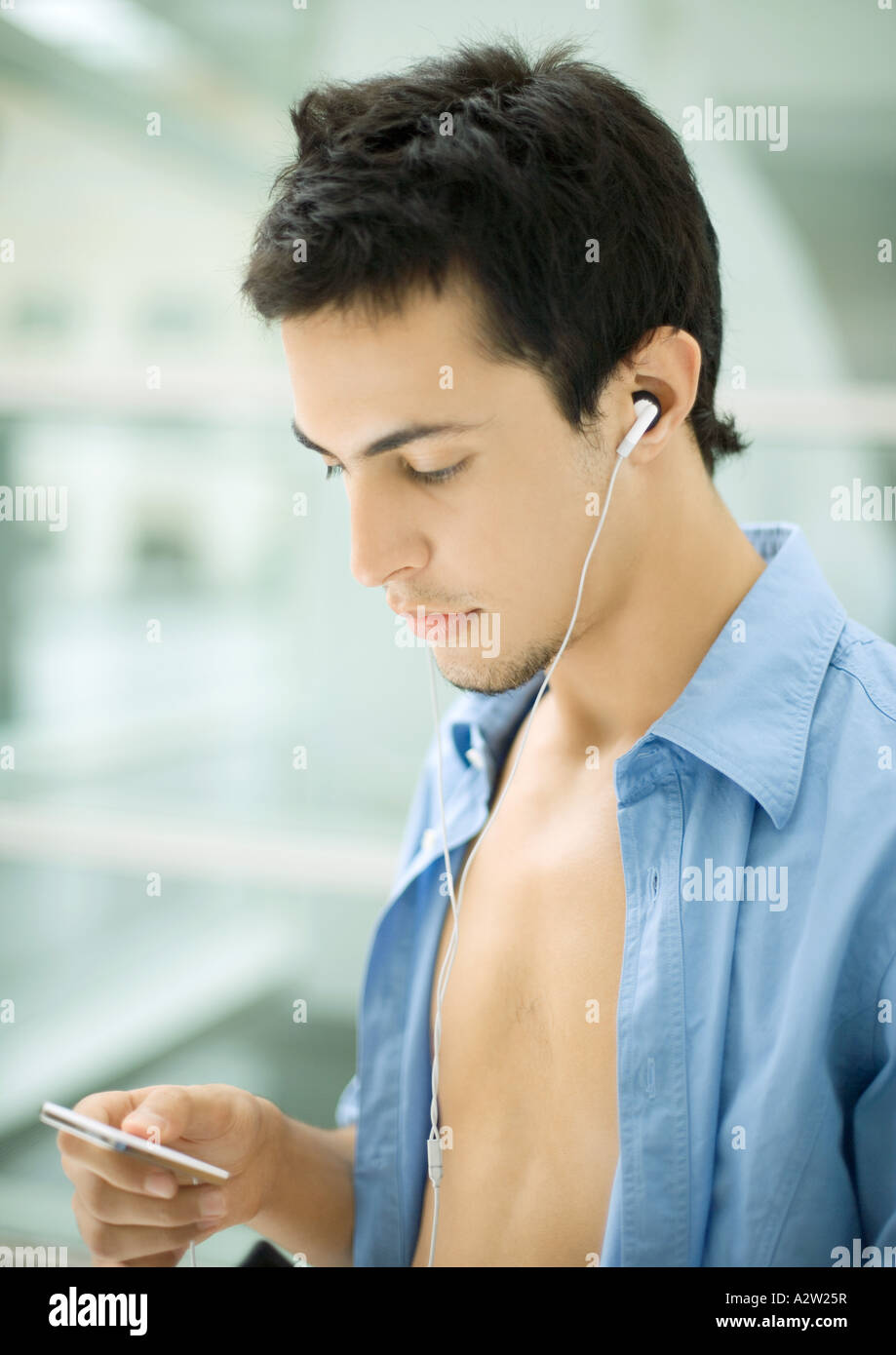 Young man listening to MP3 player Stock Photo - Alamy