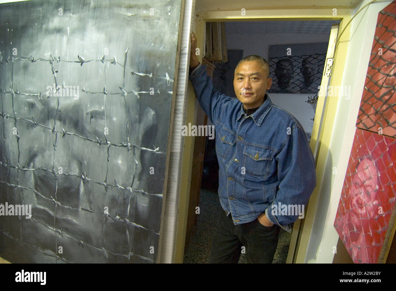 Portrait of a Chinese artist posing near one of his most striking work ...