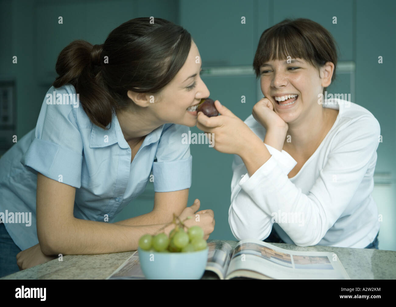 Mother eating fruit from daughter's hand Stock Photo - Alamy