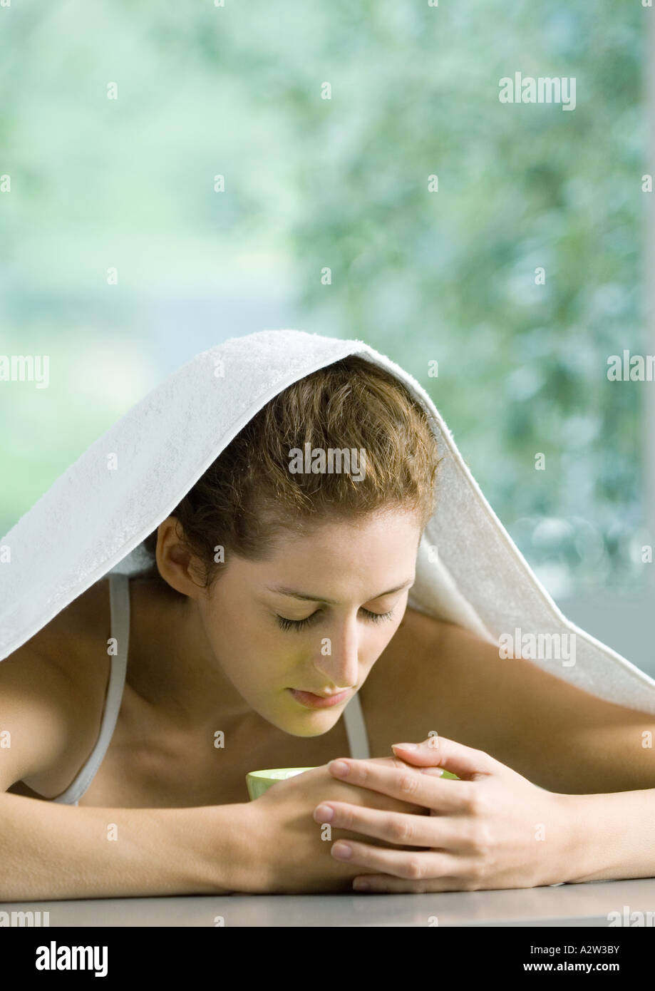 Woman leaning over bowl, towel over head Stock Photo - Alamy