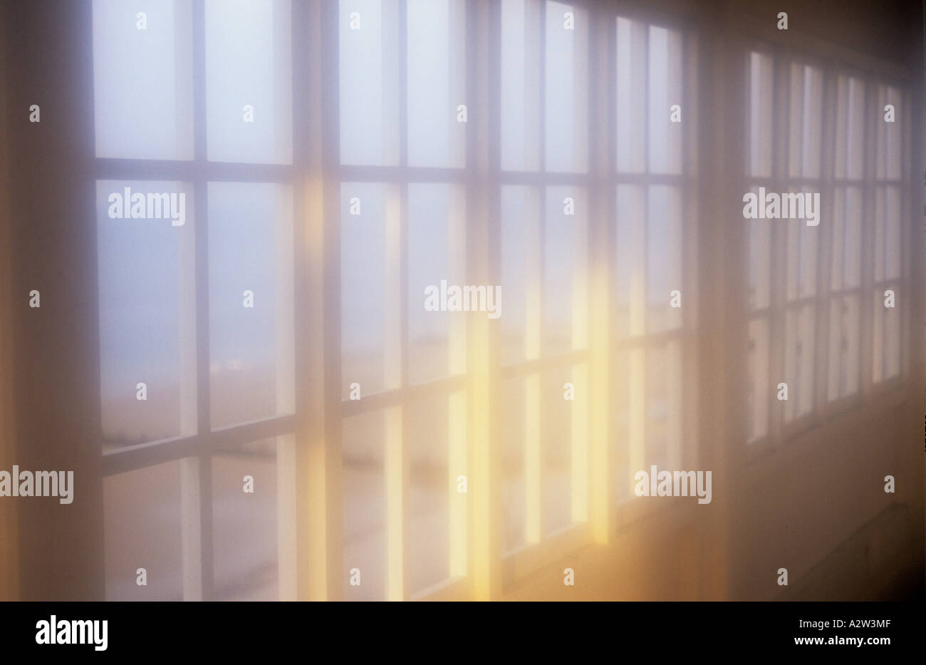 Atmospheric windows of a seaside shelter in warm golden evening light ...