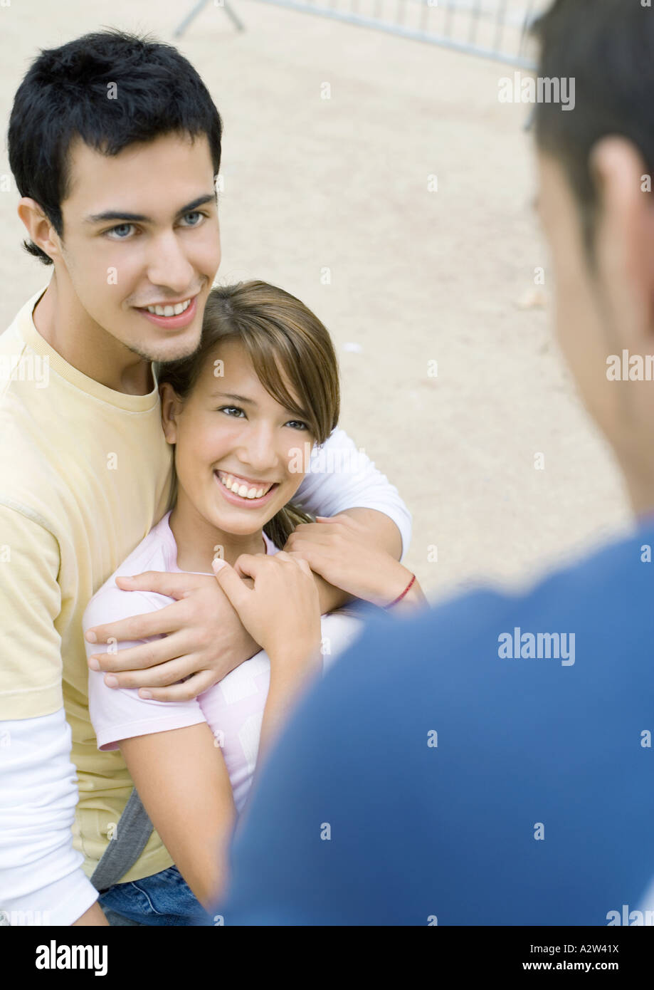 Teen couple looking at friend Stock Photo - Alamy